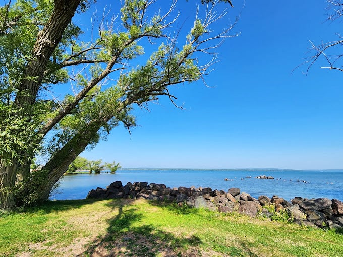 Gentle waves lap at a shore dotted with smooth stones. It's like nature's own rock collection!