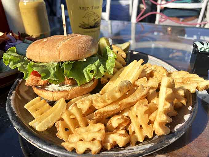 That golden pile of waffle fries next to a perfectly assembled burger proves the caf&eacute;'s excellence extends beyond seafood to landlubber favorites too.