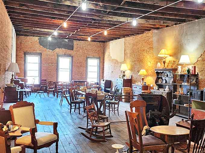 A forest of wooden chairs and tables, each with its own patina of memories, arranged like a dinner party waiting to happen.