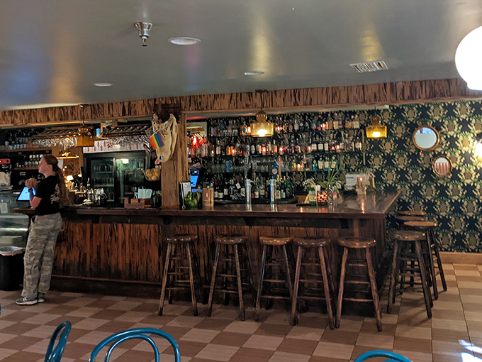 Where cocktail crafting becomes performance art against a backdrop of bottles promising liquid adventure.