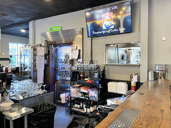 Behind the counter, organized chaos reveals a well-run kitchen &ndash; bottles lined with precision, equipment gleaming, and staff moving with confident purpose.