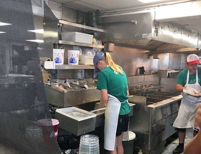 The kitchen operates with precision efficiency, churning out basket after basket of perfectly fried seafood for eager customers.
