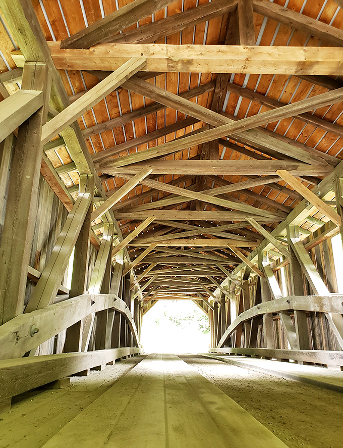 Inside the covered bridge, wooden beams create a cathedral-like atmosphere. Engineering from a simpler time that still stands strong today.