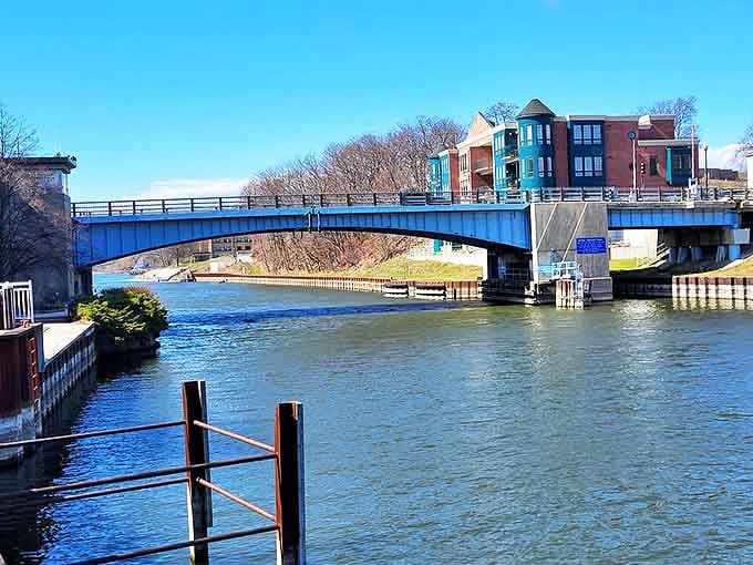 The blue bridge spans the Manistee River like a brushstroke against the sky, connecting shores while framing picture-perfect water views.