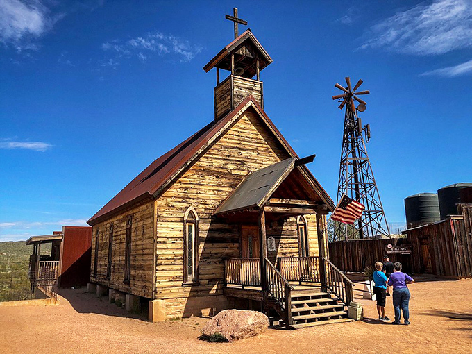 The historic church, complete with steeple and windmill, offers a moment of reflection amid the frontier recreation.
