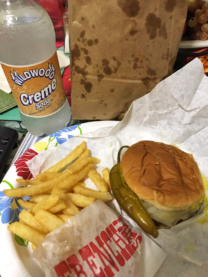 Say cheese! This cheeseburger is ready for its close-up, flaunting golden fries and a pickle sidekick.