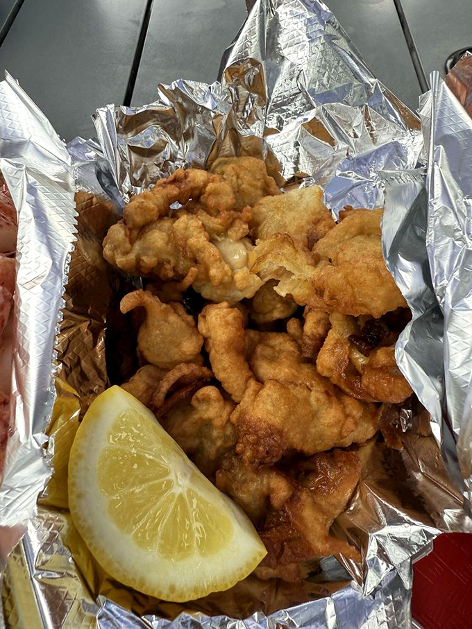 Golden fried clams nestled in foil &ndash; crispy, tender morsels of the sea that make perfect companions to any roll.