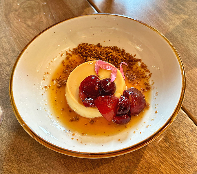 This cr&egrave;me caramel isn't just dessert, it's therapy in a bowl with cherry companions to share your deepest secrets.