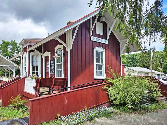 Peninsula's classic red station house serves as both functional depot and picturesque landmark, framed by the changing colors of seasonal foliage.
