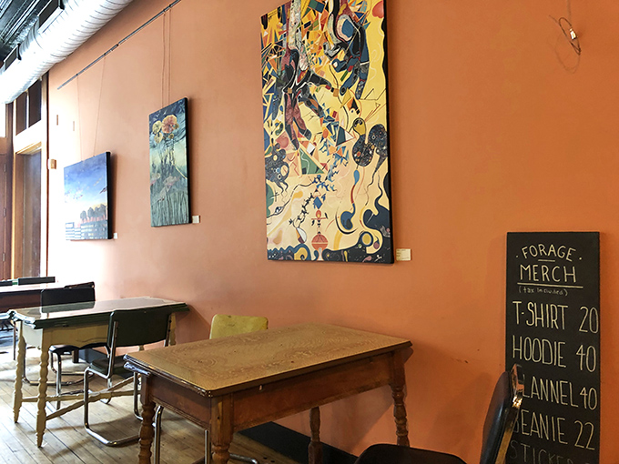 Local artwork adorns salmon-colored walls, creating a gallery-like atmosphere that celebrates community creativity alongside culinary craftsmanship.