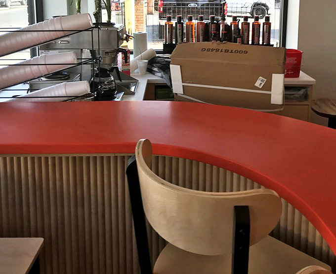 The seating area blends retro charm with modern comfort, creating the perfect spot to slow down and actually enjoy your donuts instead of inhaling them in the car.