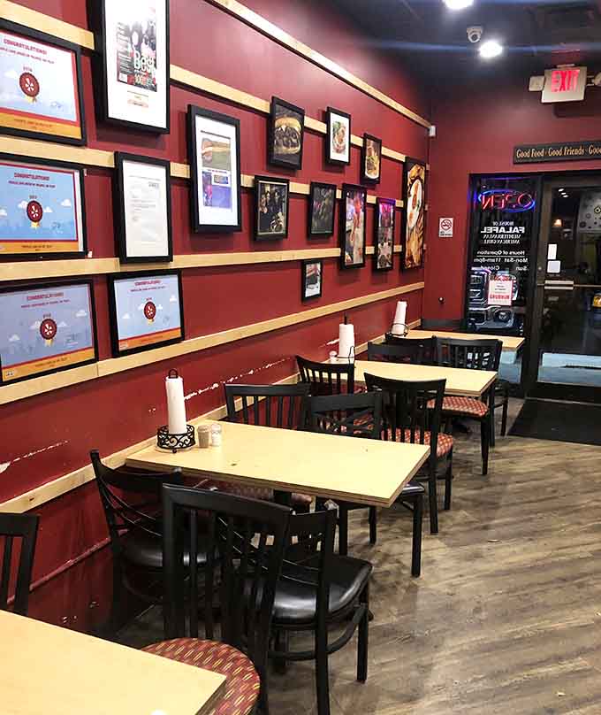 Red walls adorned with framed artwork create a warm backdrop for meals that feel like culinary journeys to distant shores.