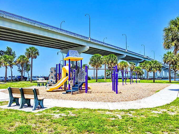 Colorful equipment stands ready beneath the causeway, where kids can burn energy while parents enjoy the waterfront views &ndash; multitasking at its finest.