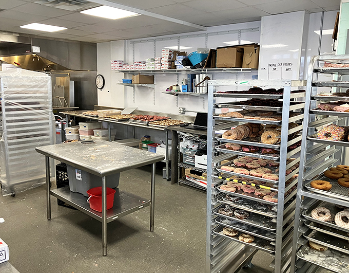 Behind the scenes in the kitchen, racks of freshly made donuts await their moment of glory &ndash; a glimpse into the organized production of joy.