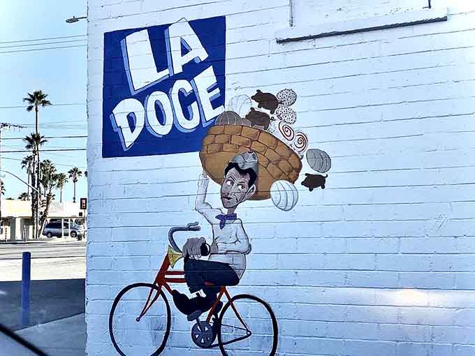 The "La Doce" mural celebrates the neighborhood's character with a bicycle-riding baker carrying the goods that made this place famous.