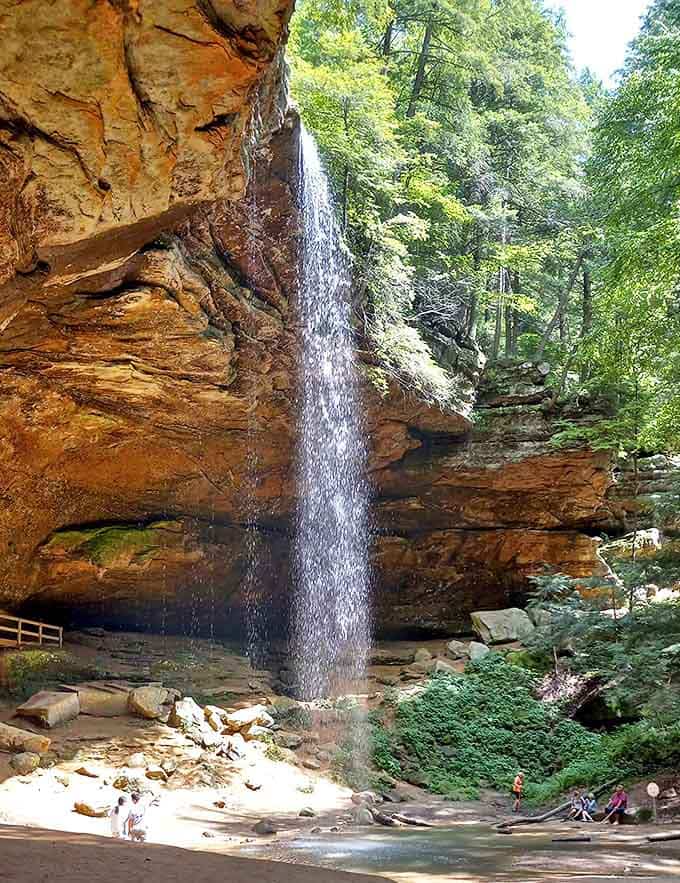 Water cascades dramatically over ancient rock formations, creating a natural shower that's been running for millennia.