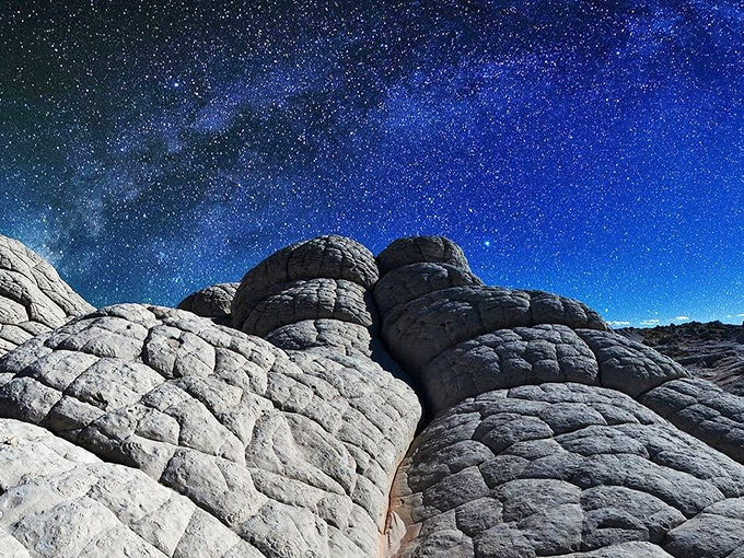 Stars performing their nightly miracle above White Pocket, the Milky Way showing off while rocks sleep below.
