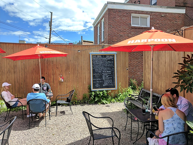 A gravel garden oasis where orange umbrellas provide shade for diners enjoying Southern flavors under Maine skies.