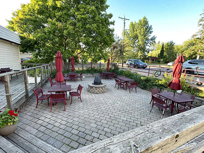 The outdoor patio offers a tranquil retreat with red umbrellas providing shade for diners enjoying the fresh air and garden ambiance.