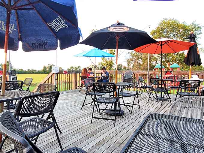 The outdoor patio offers a perfect summer escape, with colorful umbrellas shading tables where cold drinks and hot sandwiches await.