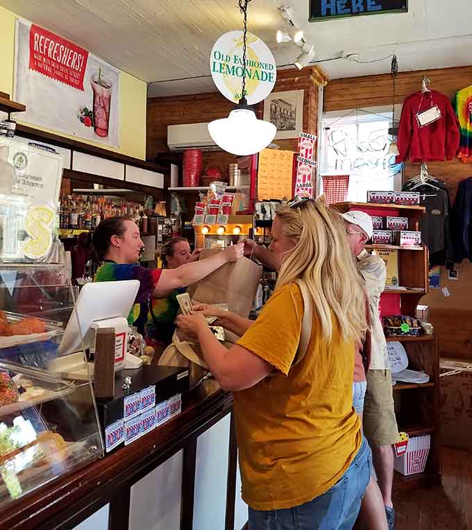 Happy customers clutching their popcorn treasures &ndash; the universal expression of "I came for one bag but somehow bought three" written across their faces.