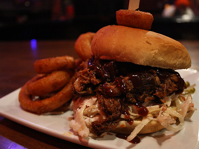 The pulled pork sandwich &ndash; tender, smoky meat piled high on a soft bun with crispy onion rings on the side. Southern comfort with Vermont sensibility.