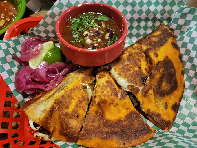 Perfectly grilled quesadillas with a side of birria consomm&eacute; - comfort food that speaks the universal language of cheese.