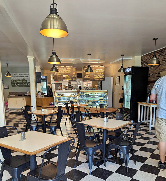 Industrial pendant lights illuminate a space where every detail matters, from the carefully arranged pastries to the thoughtfully designed seating area.