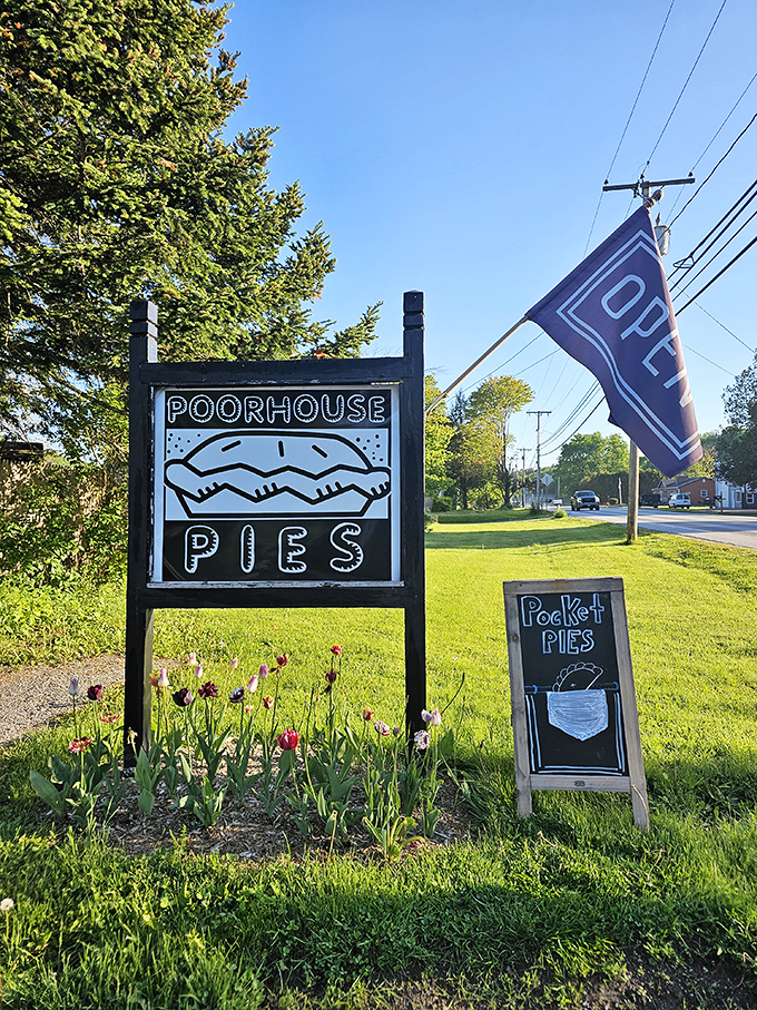 The Poorhouse Pies sign stands like a roadside shrine to pastry perfection, complete with pocket pie announcement for the faithful.