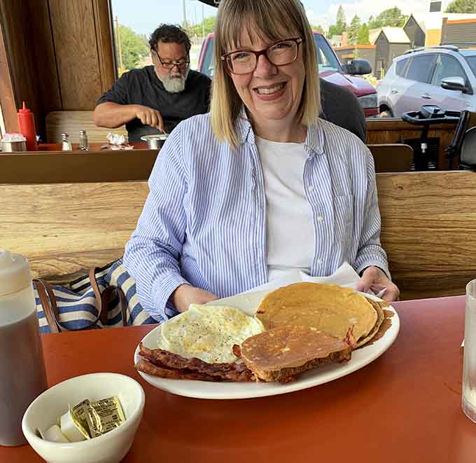 That smile says it all: when your pancake is literally the size of the plate, you know you've made excellent life choices.