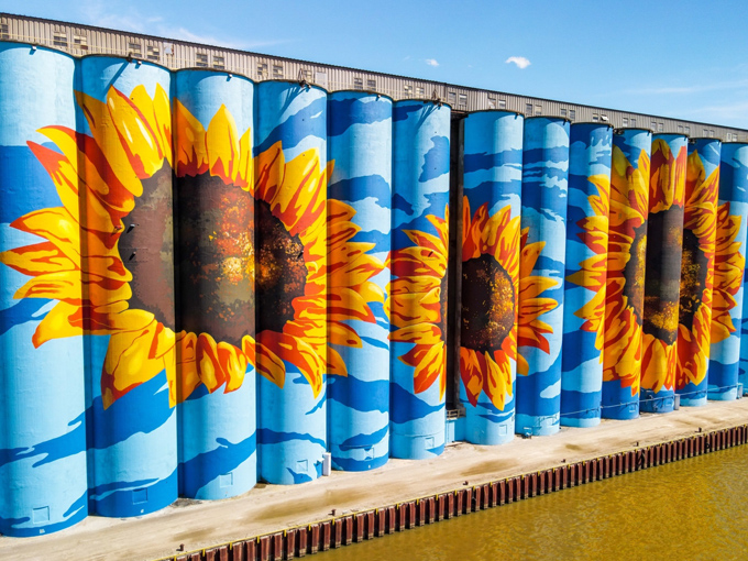 Each sunflower contains intricate details that reward closer inspection, from textured centers to delicately rendered petals catching the breeze.