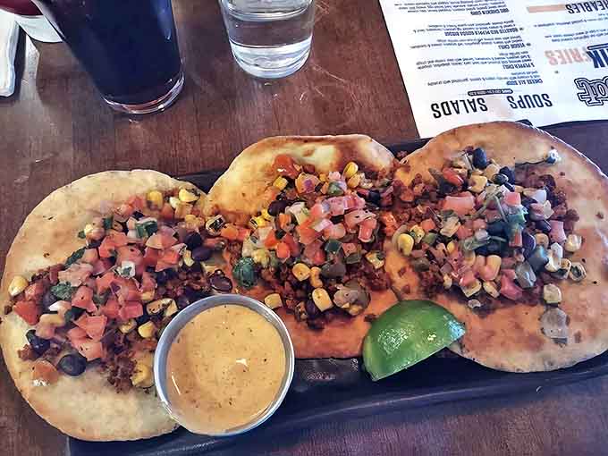 Soft tortillas cradle colorful fillings and a side of zesty sauce, showing that HopCat's culinary skills extend well beyond American classics.