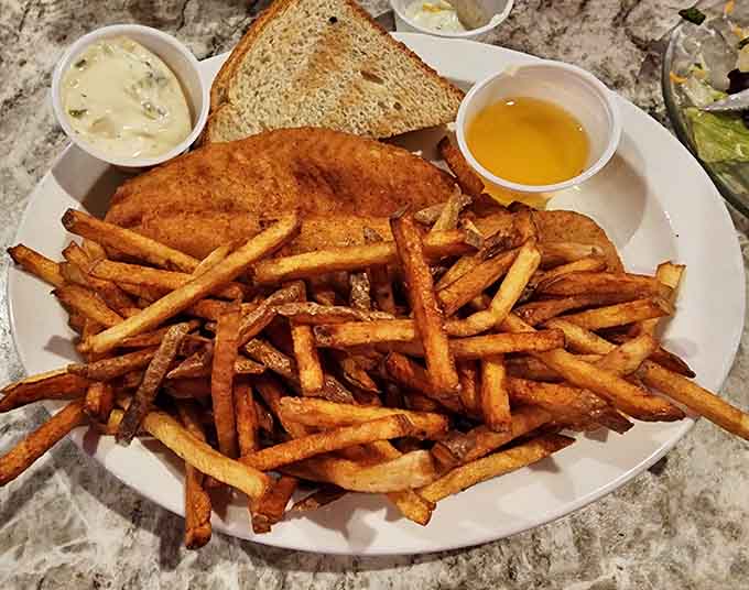 A mountain of perfectly seasoned fries with dipping sauces proves that side dishes deserve respect and attention too.