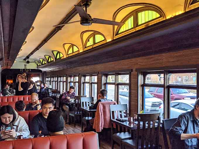 Happy diners enjoy their meals in the cozy space, where the intimate atmosphere encourages conversation and the universal joy of really good noodles.