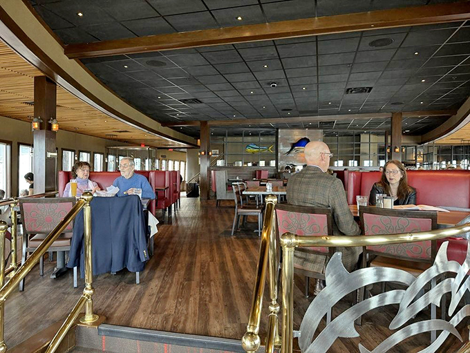 The upper dining section offers intimate seating with brass railings and warm lighting that evokes the golden age of ocean travel.