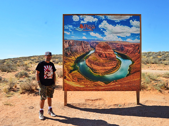 "I was here!" A visitor poses beside the iconic Horseshoe Bend sign, capturing proof of pilgrimage to this bucket-list destination.