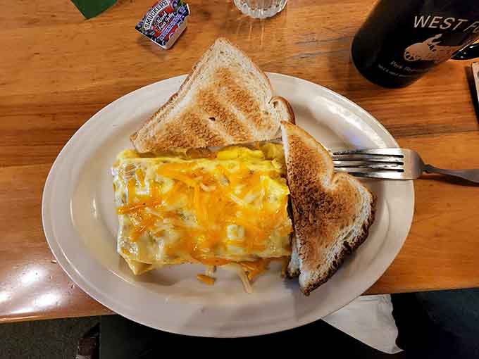 A cheese-covered omelet with toast demonstrates that sometimes the simplest breakfast combinations are the ones that satisfy most completely and deliciously.