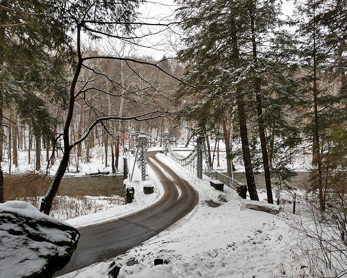 Winter's quiet solitude offers a different perspective of the bridge, with snow-covered paths leading to its entrance.