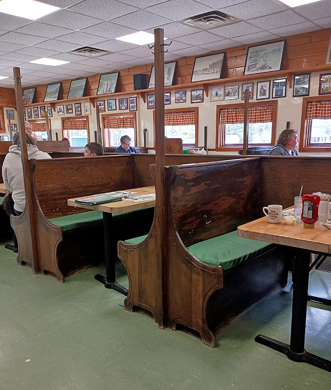 Wooden church-pew style booths create intimate dining spaces where conversations flow as freely as the coffee.