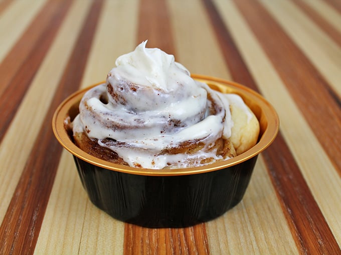 This spiral of cinnamon goodness sits in its golden container like royalty, waiting to transform an ordinary moment into something memorable.