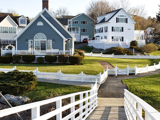 White picket fences and manicured lawns frame classic New England architecture &ndash; coastal living at its most picturesque.