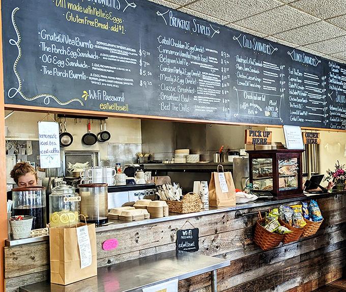 The counter showcases the café's soul – handwritten signs, fresh flowers, and that "made with love" feeling that corporate chains try to fake.