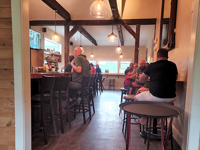 The bar area hums with conversation as patrons gather to enjoy craft cocktails and share stories in this hidden Maine gem.