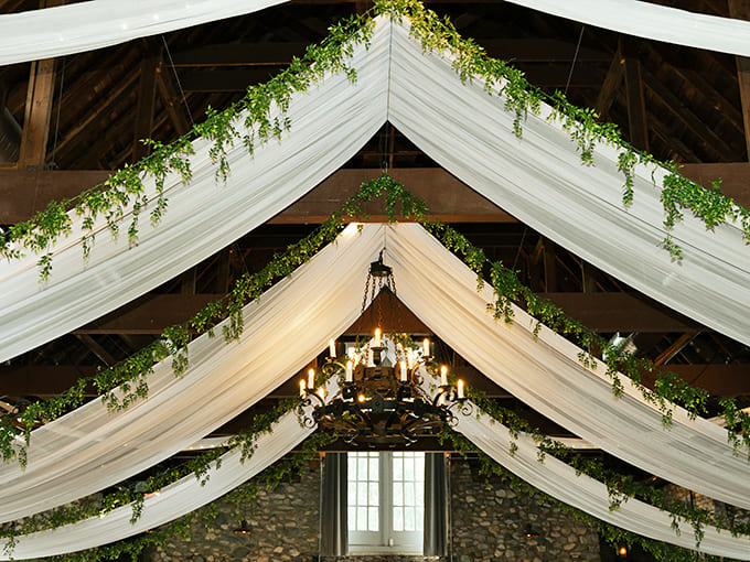 Look up! Flowing fabric and greenery transform this ceiling into a canopy of elegance, proving that even castle interiors deserve the royal treatment.