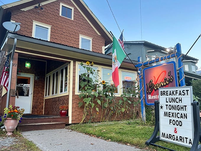 The restaurant's entrance, with flags fluttering in the Vermont breeze, hints at the culinary diversity waiting within this beloved local institution.