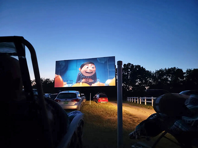 The massive screen stands ready against the twilight sky, about to transport hundreds of viewers into different worlds.