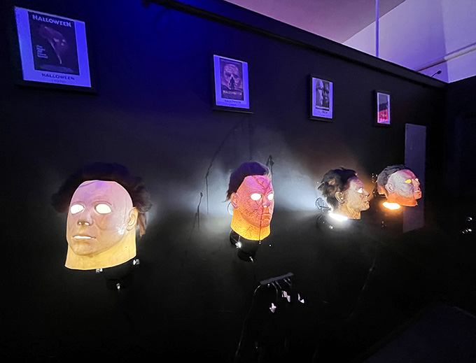 Horror movie masks mounted like trophies, each one representing a different flavor of fear for your consideration.