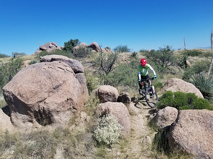 Mountain bikers find their thrills navigating between ancient boulders, where every turn offers both challenge and reward.