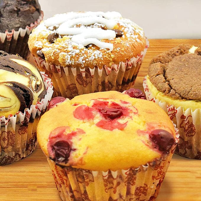 These muffins aren't afterthoughts – they're co-stars in this bakery show, with flavors from classic blueberry to decadent chocolate swirl.