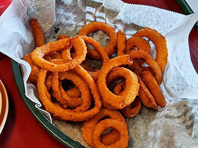 A perfect diner spread &ndash; golden onion rings, hearty sandwiches, and that essential cup of coffee that keeps the conversation flowing.